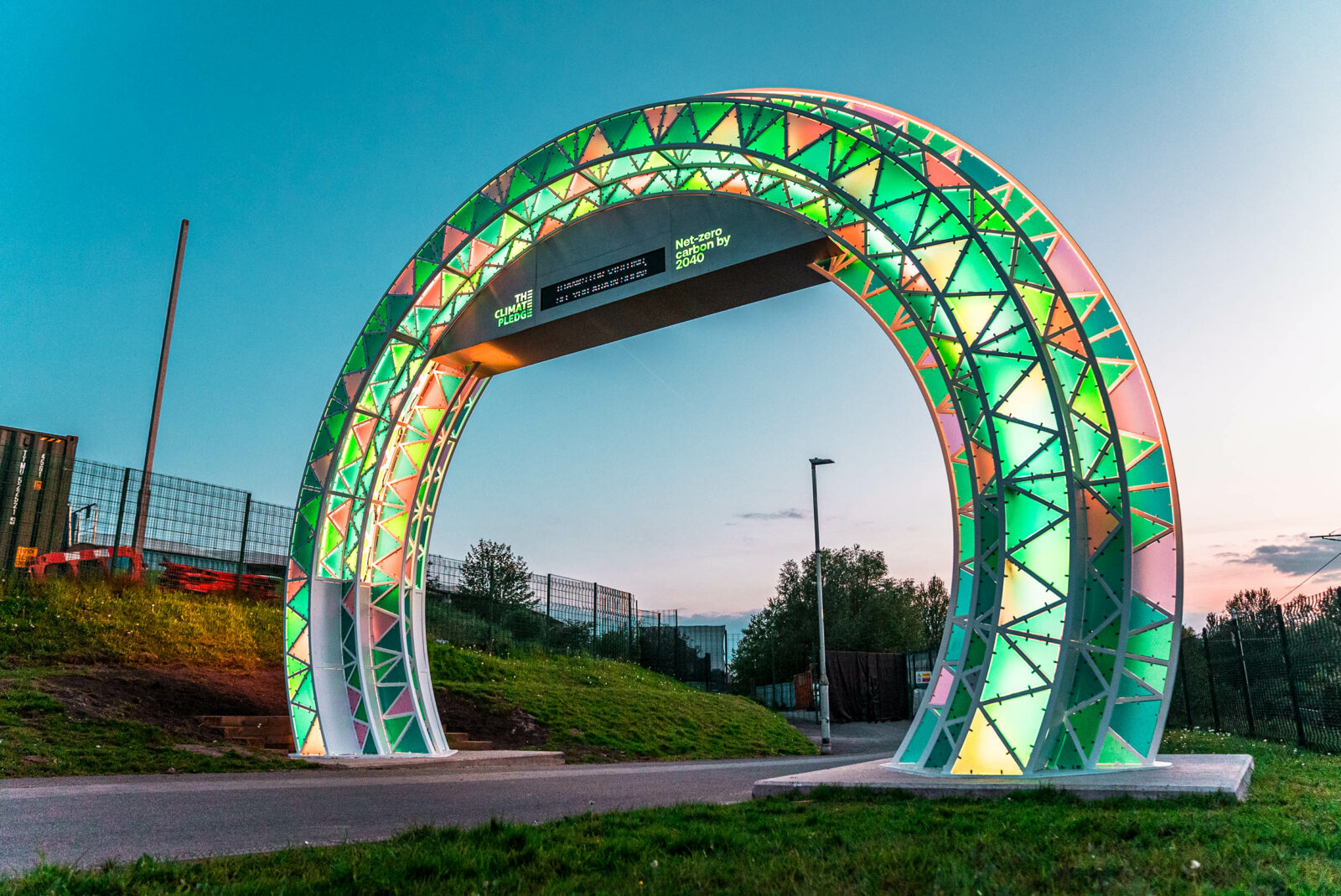 A white painted steel arch fitted with multi-coloured acrylic panels ...